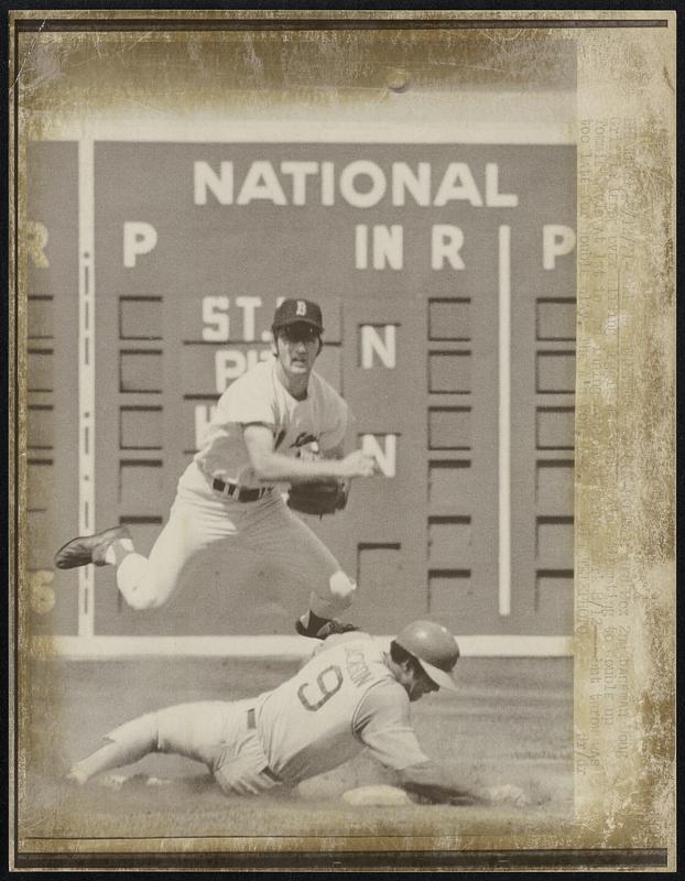 Red Sox 2nd baseman Doug Griffith leaps over sliding Reggie Jackson of ...