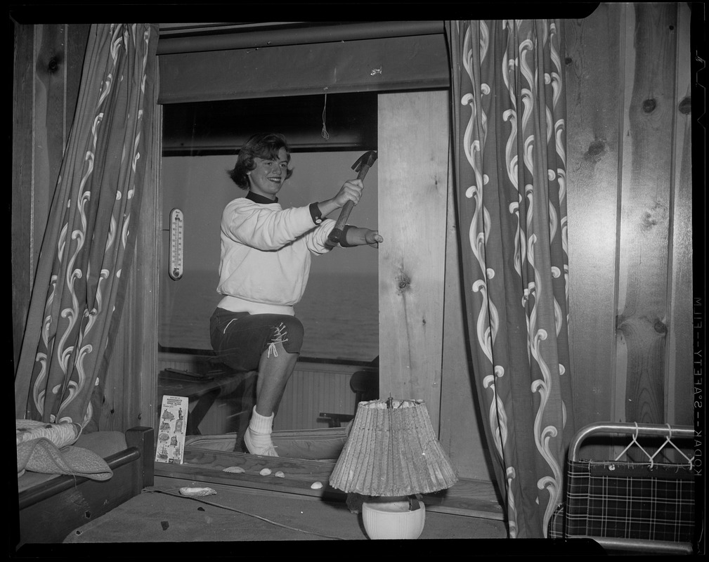 Woman using a hammer to board up a window in preparation for Hurricane ...