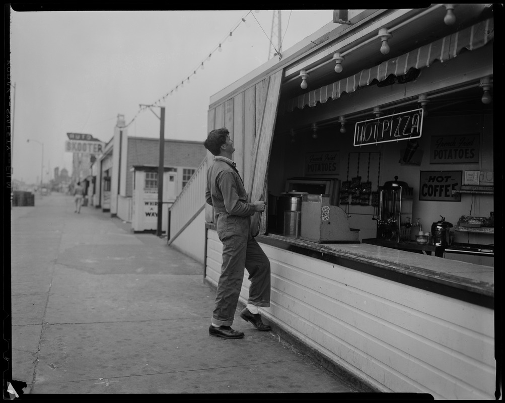Man boarding up windows of a concession stand in preparation for ...