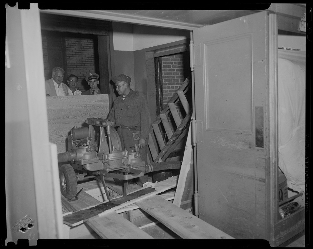 Four men looking at a machine - Digital Commonwealth