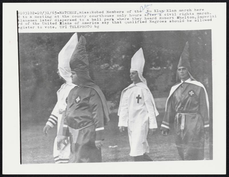 Robed Members of the Ku Klux Klan march here to a meeting at the county ...