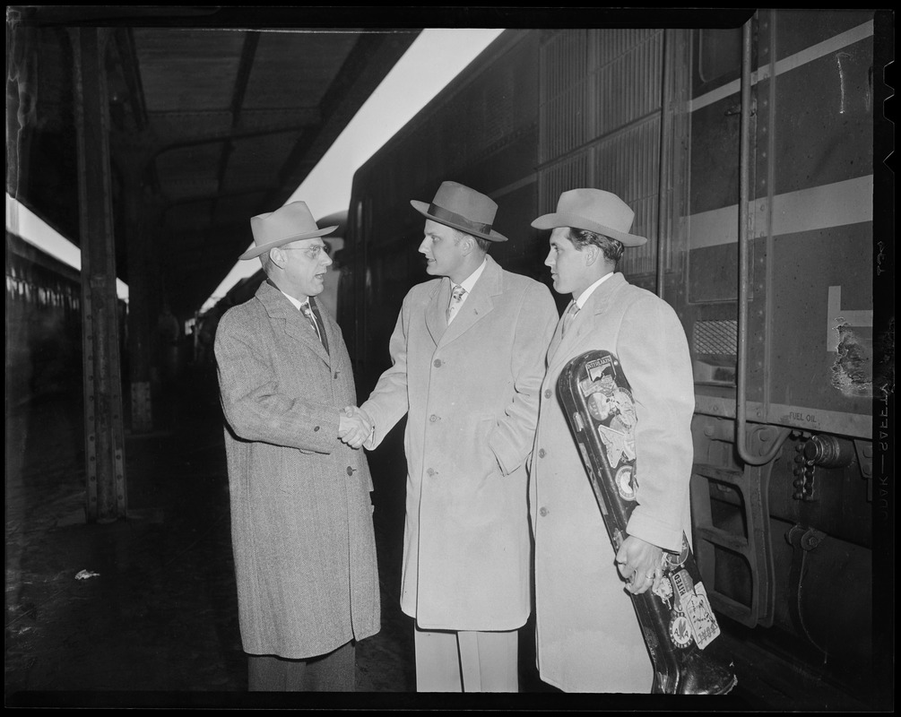 Billy Graham shaking hands with man, while Cliff Barrows looks on ...