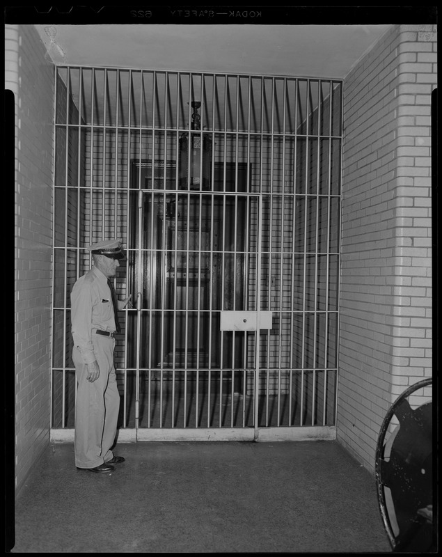 Guard standing in front of caged door - Digital Commonwealth