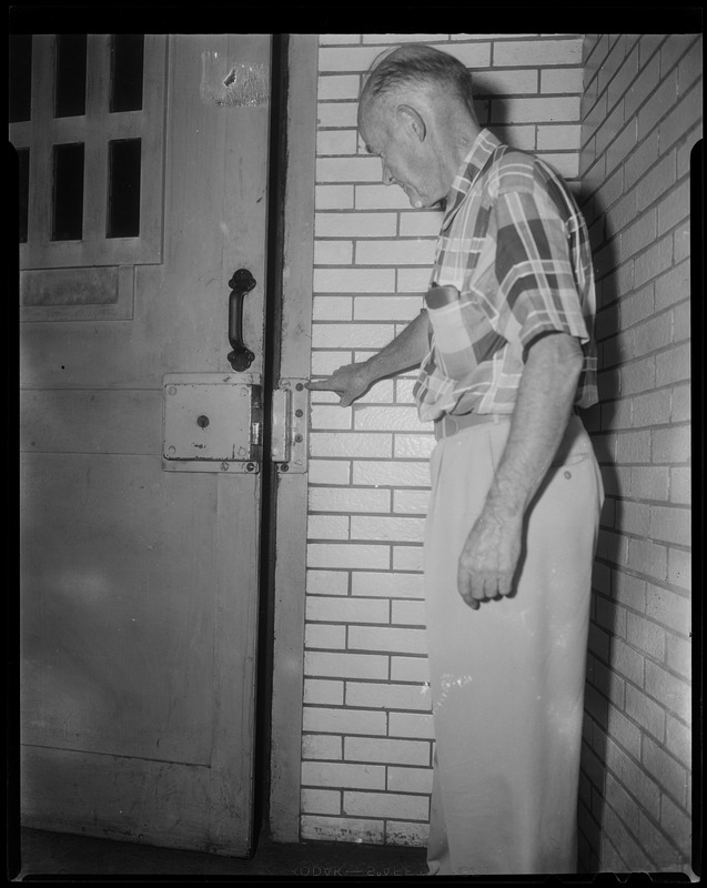 Man pointing to door and lock - Digital Commonwealth