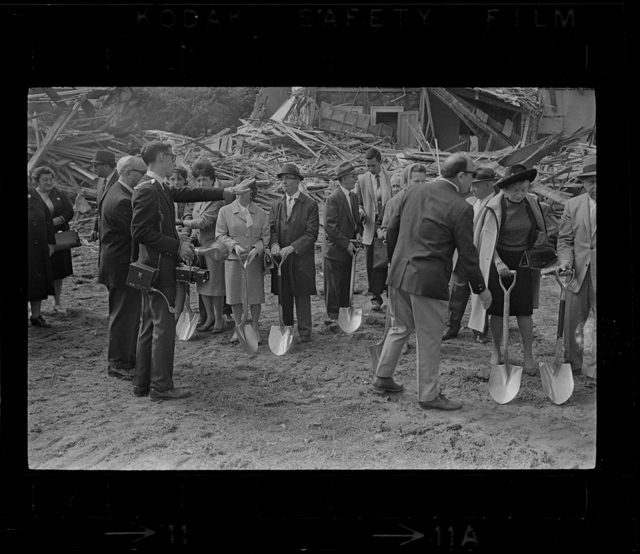 Crowd of people standing in front of destroyed building and holding ...