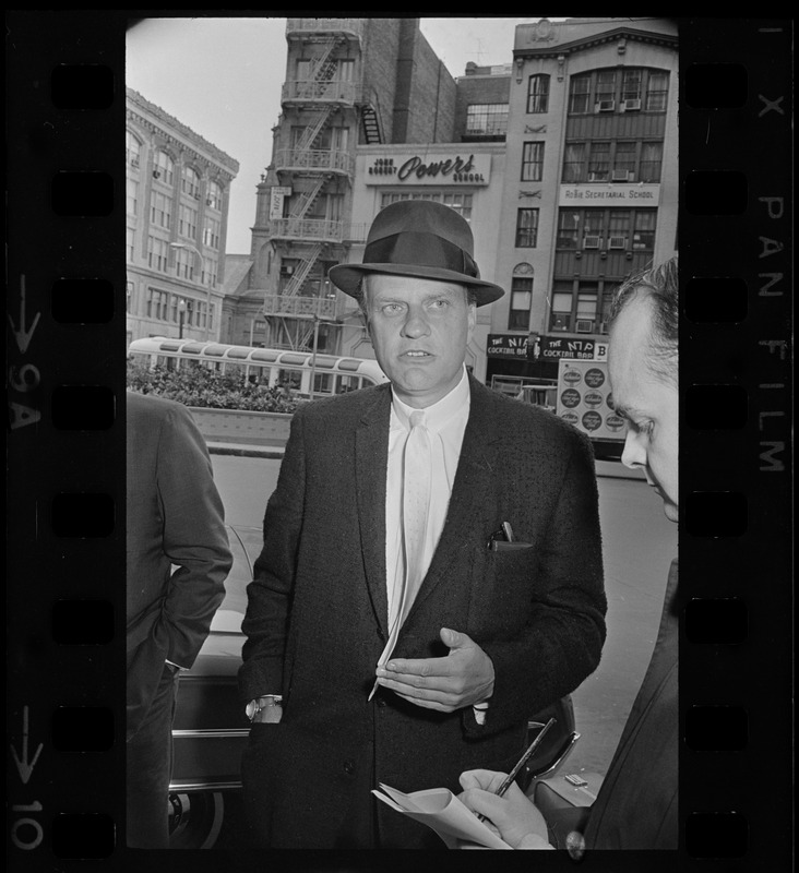 Billy Graham with hat on outside of Hotel Statler Hilton in Boston ...