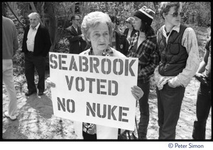 Local resident (an older woman) holds up a sign reading 'Seabrook voted ...