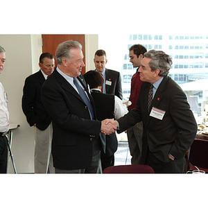 A guest shakes hands with Northeastern President Richard Freeland at ...