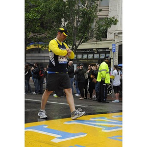 One runner checking the time as he crosses the "One Run" finish line in ...
