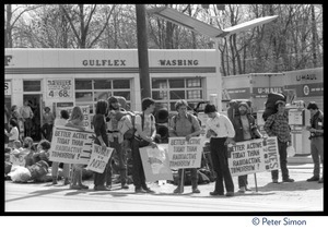 Protester gathered outside a service station with signs reading 'Better ...
