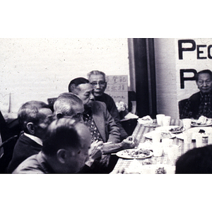 Members of the Chinese Progressive Association sit with plates of food ...
