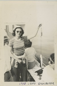 Bernice Kahn holding up a fish on a line - Digital Commonwealth