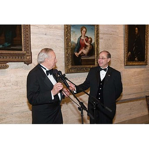 President Aoun stands with a man at a microphone at the inauguration ...