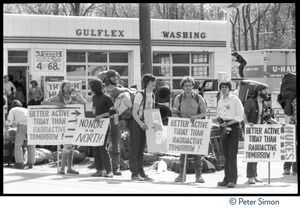 Protester gathered outside a service station with signs reading 'Better ...