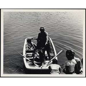 Frederick Davis, Executive Vice President, standing in a rowboat with a ...