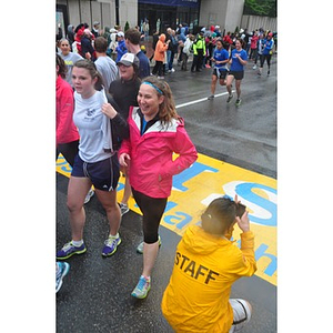 A runner smiles after crossing One Run finish line - Digital Commonwealth
