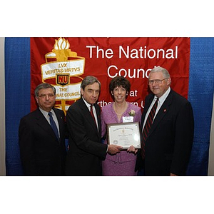 Maureen Gaughan poses with three men at the National Council Dinner ...