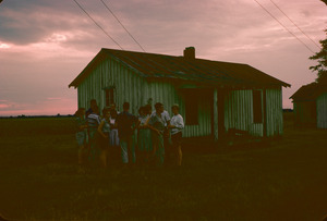 Several volunteers gather in front of migrant labor shack - Digital ...