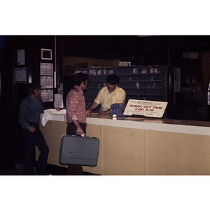 Two men checking in at YMCA front desk - Digital Commonwealth
