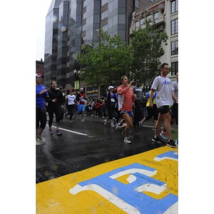 Numerous "One Run" participants approach the Copley Square finish line ...