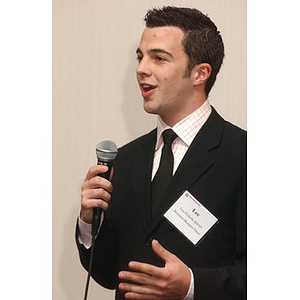 Lee Pichette speaks into a microphone at The National Council Dinner ...