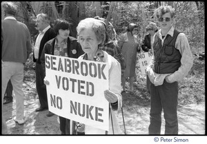 Local resident (an older woman) holds up a sign reading 'Seabrook voted ...