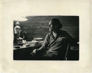 Sam Lovejoy, seated at a desk, Montague Farm Commune - Digital Commonwealth