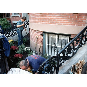 Two men landscaping the small garden in front of a Villa Victoria ...